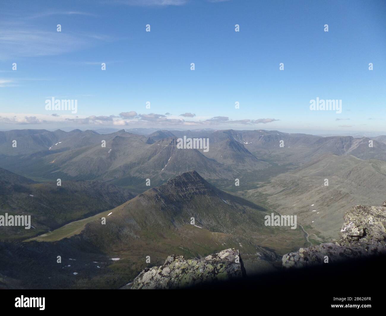 Mountain landscape with peaks, valleys, green grass, rocks and gray ...
