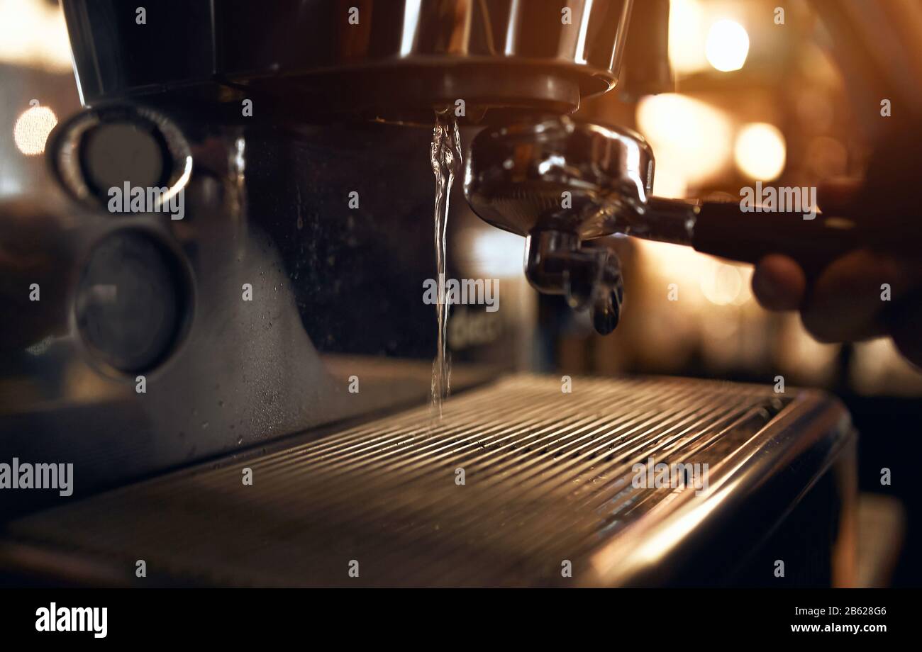 Boiling water pouring from coffeemachine, close up side view photo ...