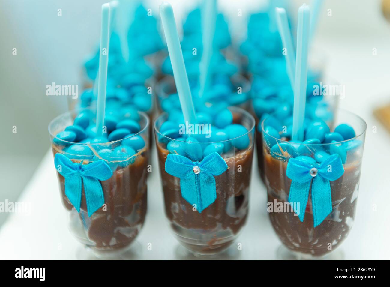 Close up of chocolate pudding brown into cup plastic with blue spoon ...