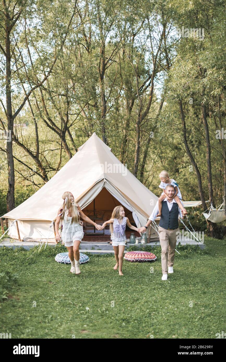 Happy family: mother, father, two daughters on nature on summer sunset ...