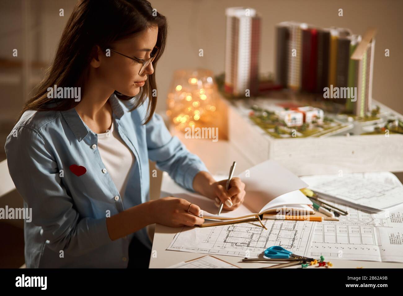 architect making corrections while sitting at workplace, close up side ...