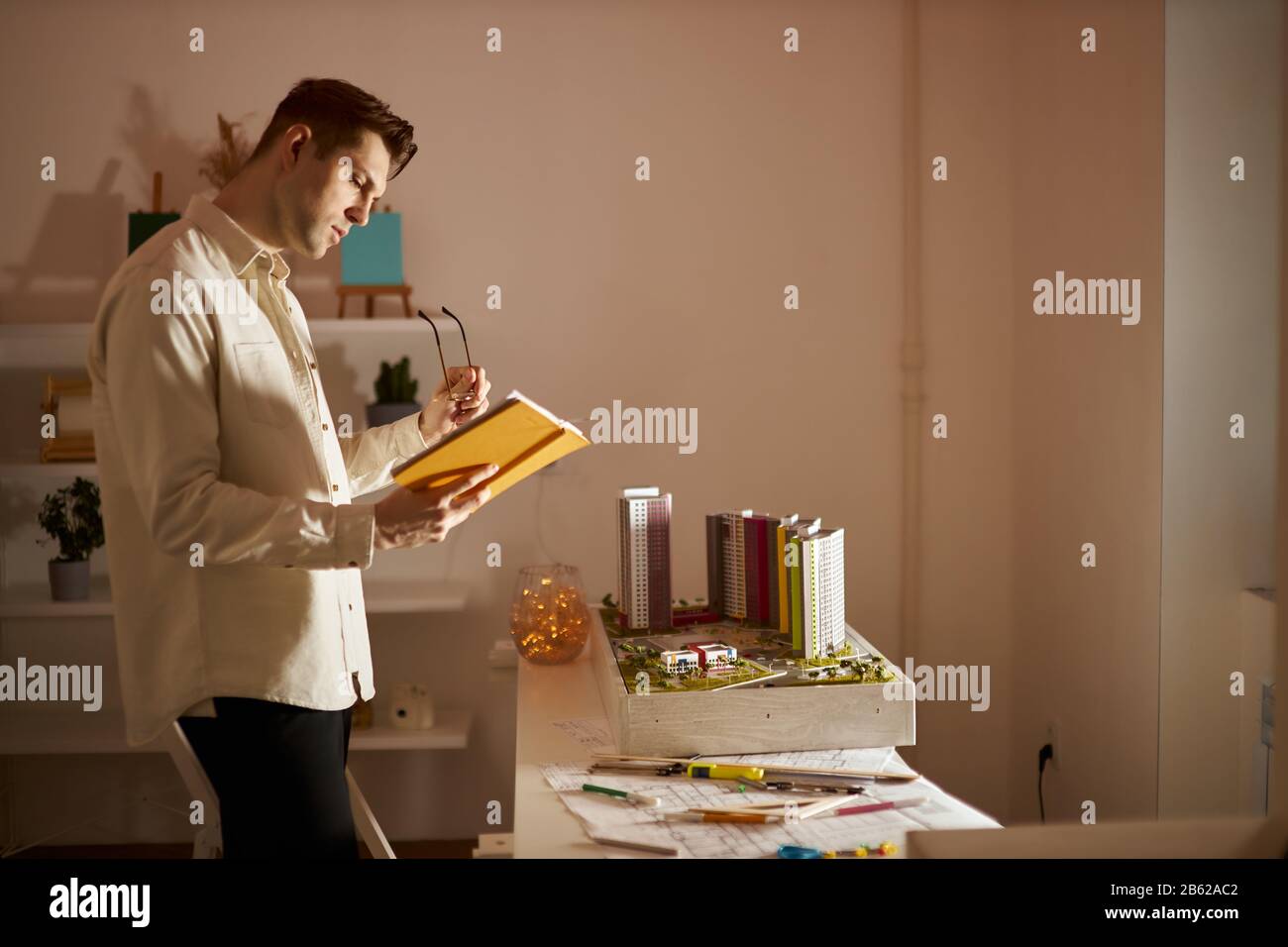 designer concentrated on reading instructions from the book, close up ...