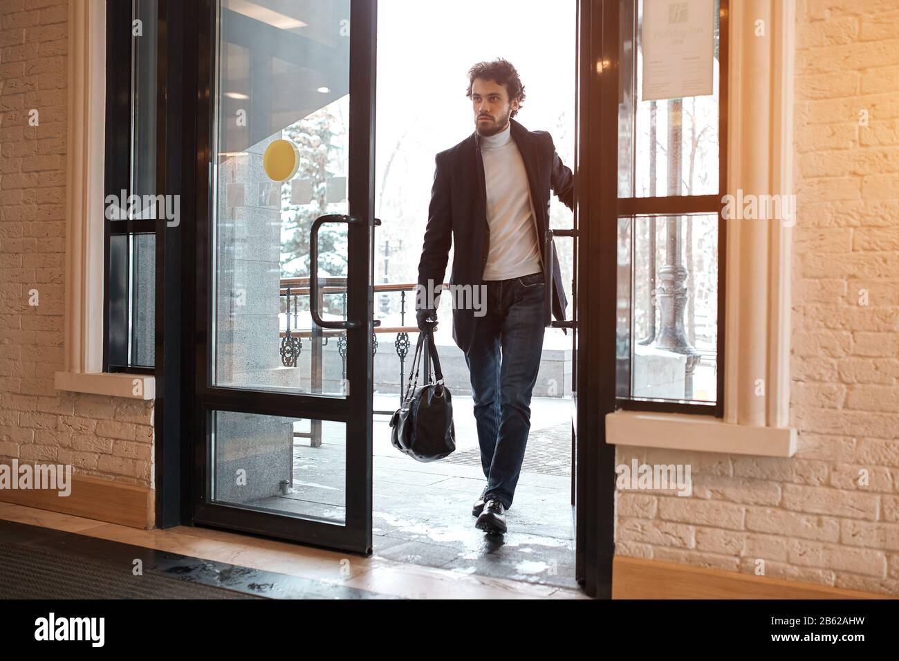 young attractive businessman in fashion clothes entering , going to the ...