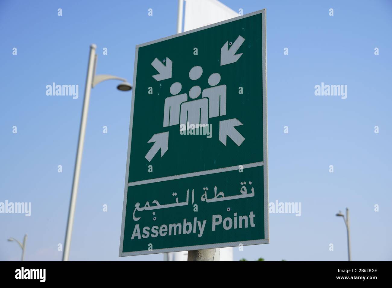 Emergency assembly point information sign in white paint on green ...