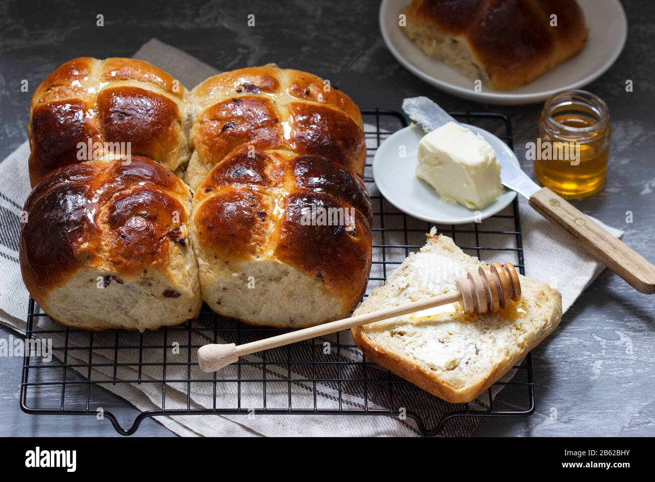 Traditional hot cross buns with honey and butter on a concrete ...