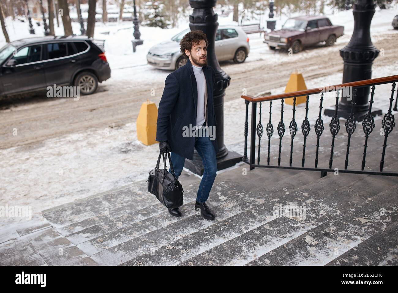 young successful businessman coming up the stairs, full length photo ...