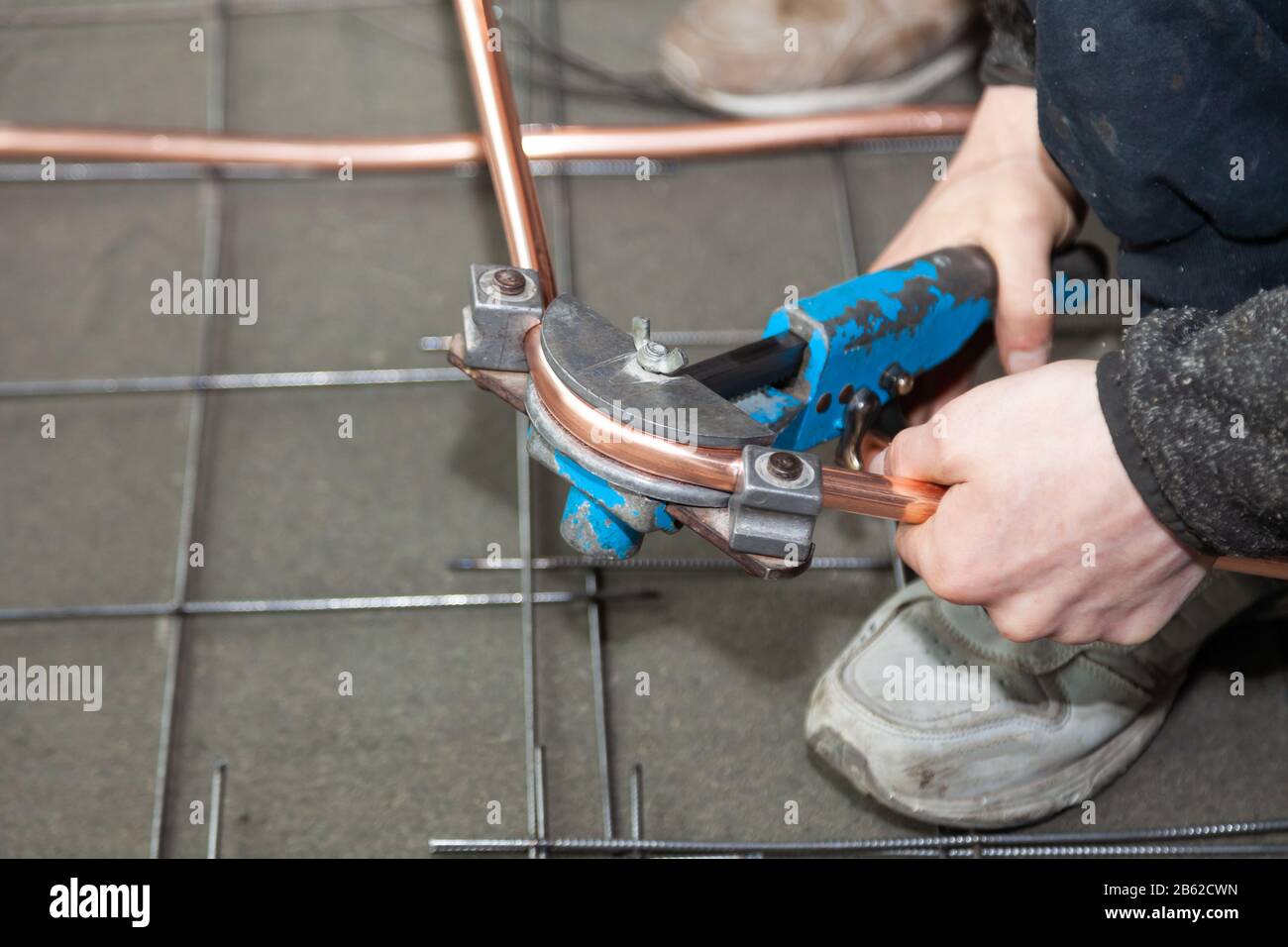 plumber hands bends copper pipes by pipe bender Stock Photo - Alamy