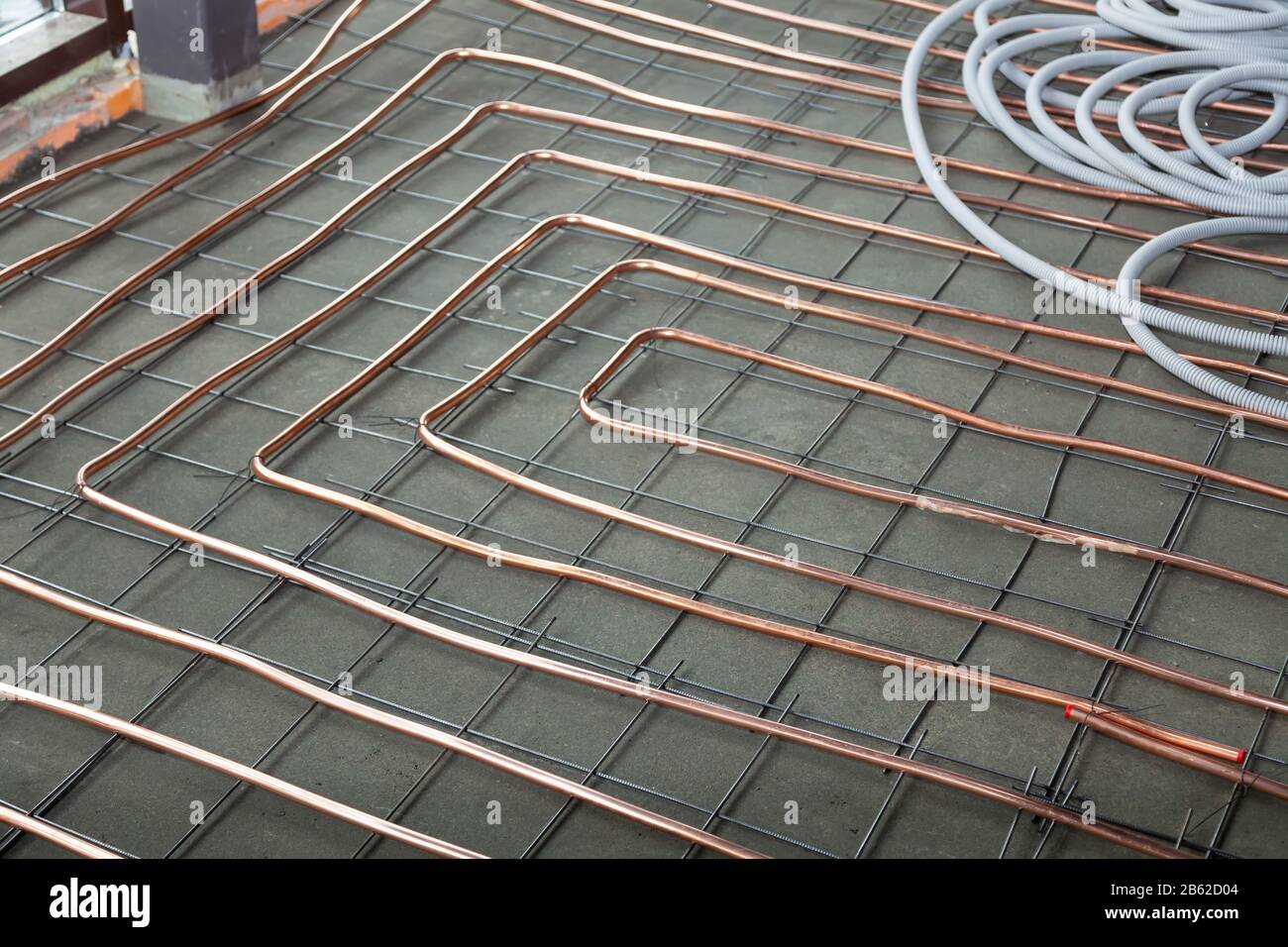 Bent new copper pipes laying on concrete floor Stock Photo - Alamy