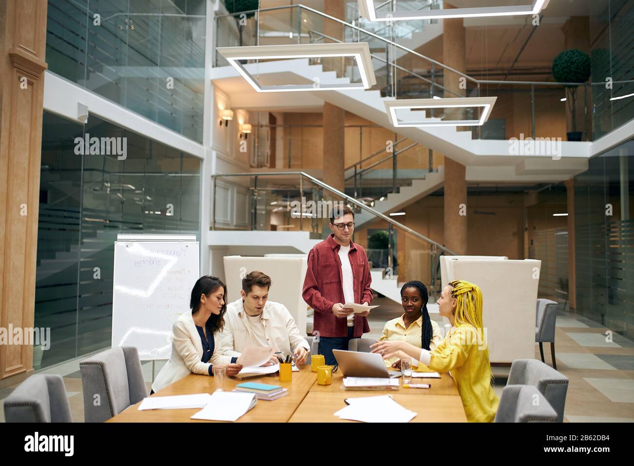 young clever man consulting his colleagues during the meeting. handsome ...