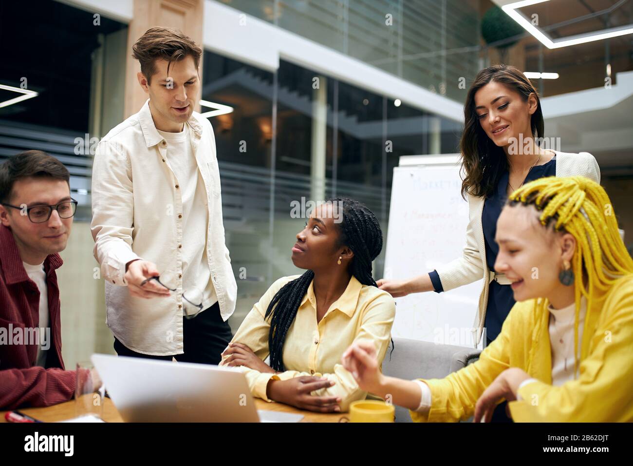 cheerful active young people watching video lesson in the office with ...