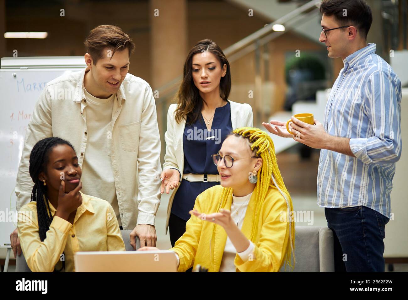 beautiful girl with yellow dread explaining something to her colleagues ...