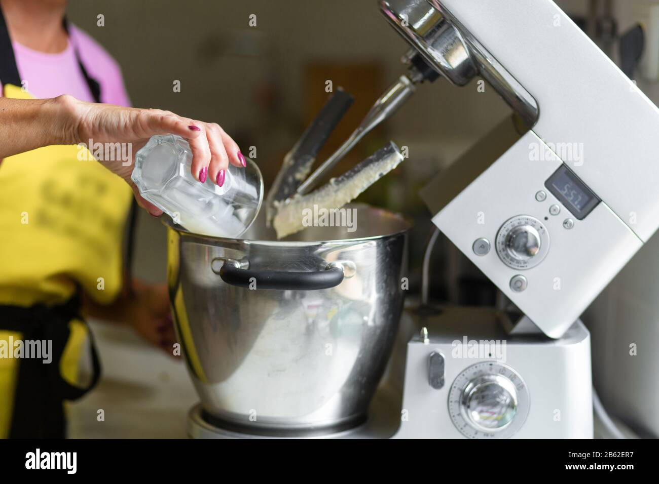 Woman professional pastry chef preparing a dessert. Adds ingredients ...