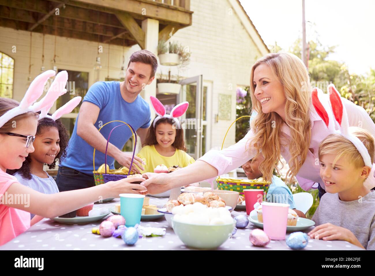Parents With Children Wearing Bunny Ears Enjoying Outdoor Easter Party ...