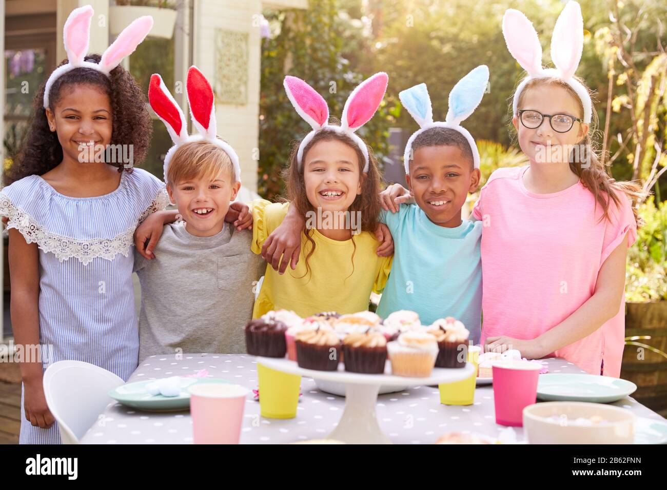 Portrait Of Children Wearing Bunny Ears Enjoying Outdoor Easter Party ...