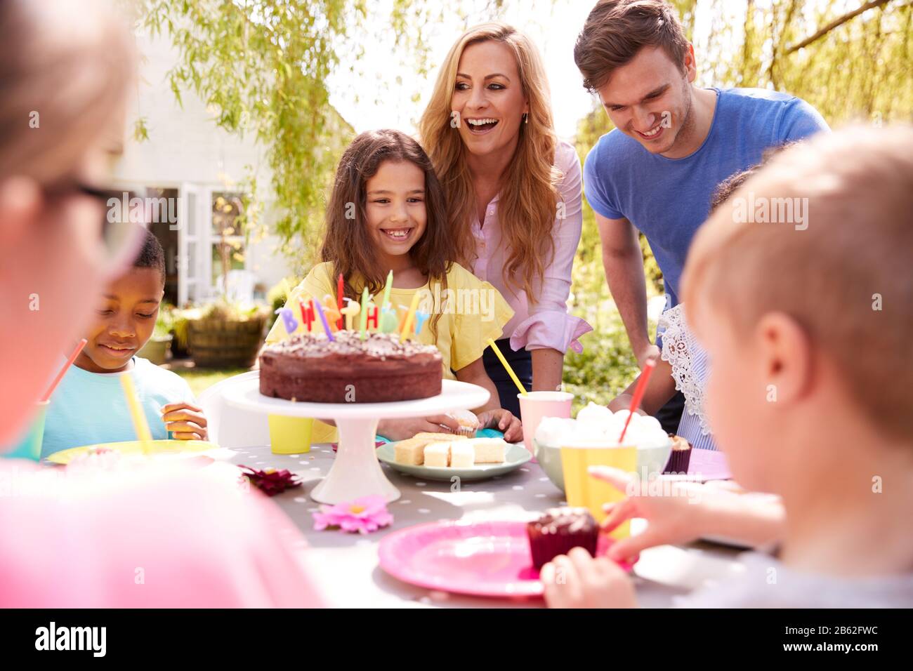 Parents And Daughter Celebrating Birthday With Friends Having Party In ...