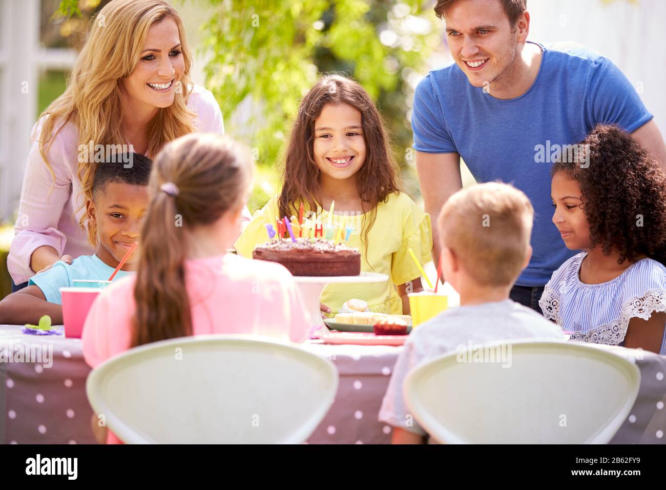 Parents And Daughter Celebrating Birthday With Friends Having Party In ...