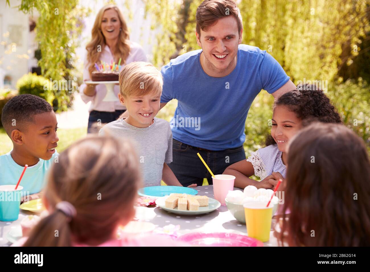 Parents And Son Celebrating Birthday With Friends Having Party In ...
