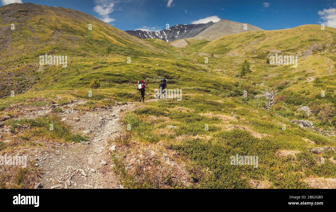 Two hikers walk up on mountain pass, Altai, Russia Stock Photo - Alamy