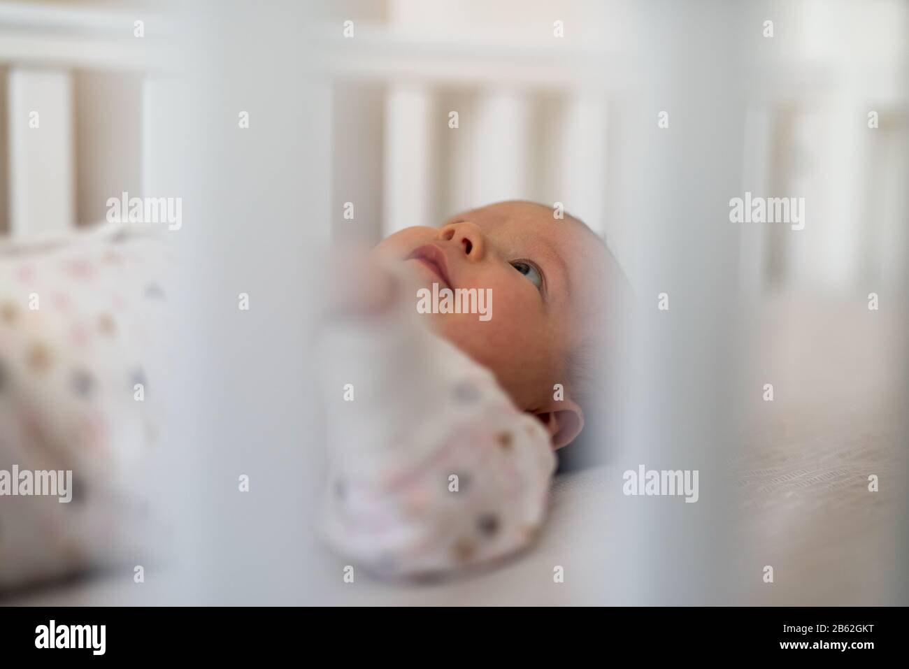 Lovely newborn baby girl in bed, view through crib bars Stock Photo - Alamy