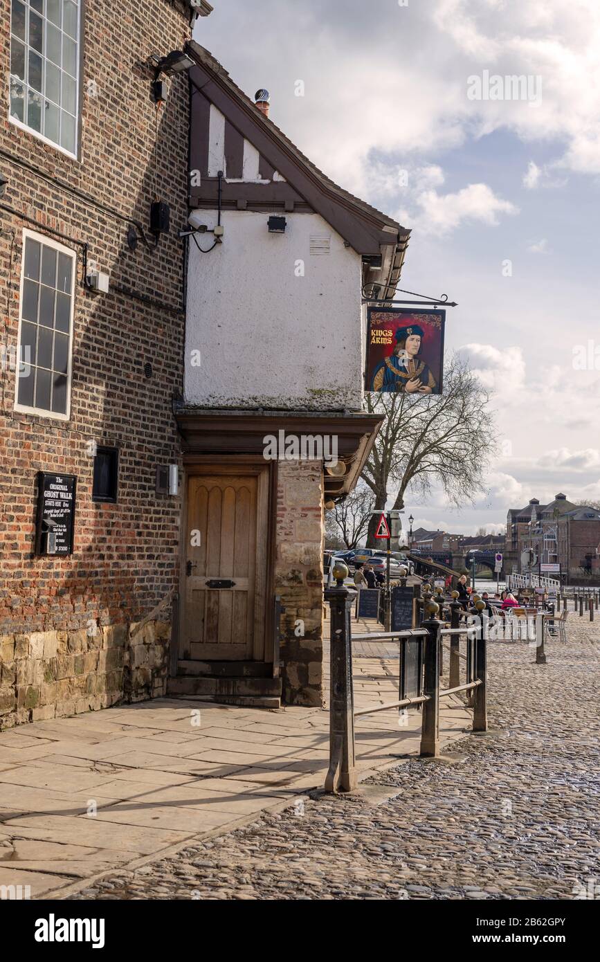 Riverside pub in York. The ancient building is beside a cobblestone ...