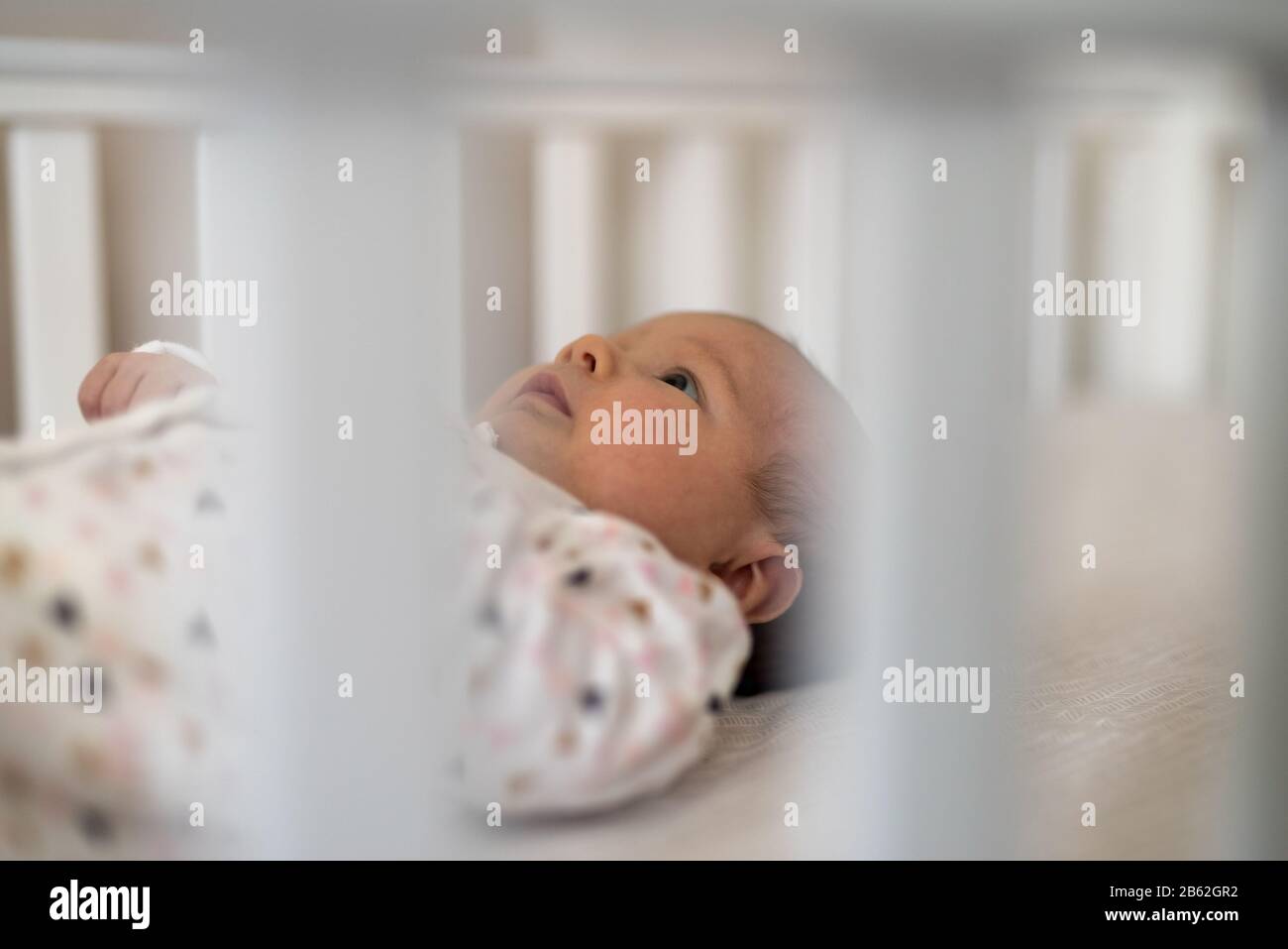 Lovely newborn baby girl in bed, view through crib bars Stock Photo - Alamy