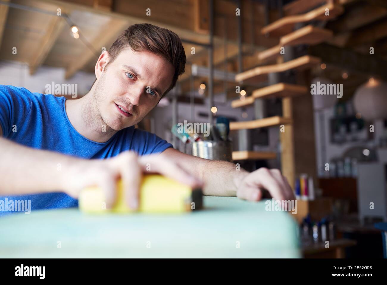 Man In Workshop Upcycling And Working On Furniture With Sandpaper Stock ...