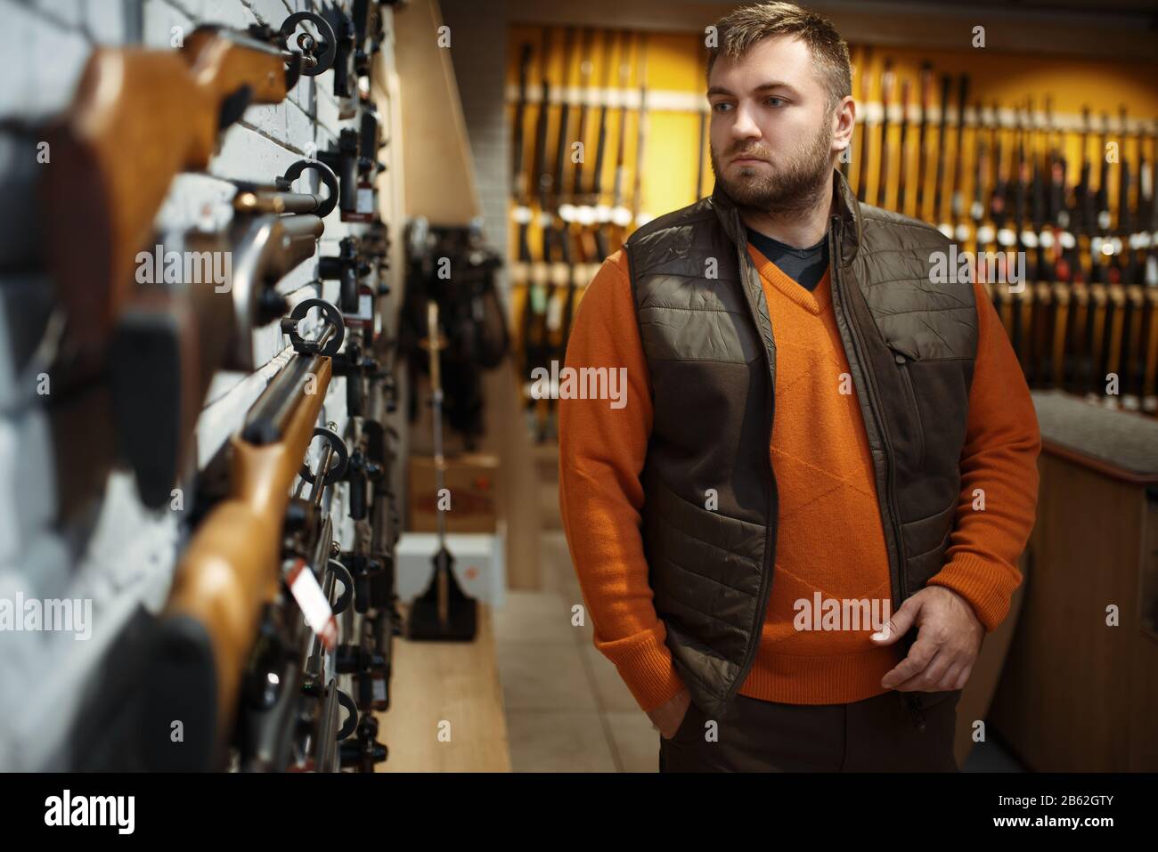 Man at showcase with rifles, back view, gun shop Stock Photo - Alamy