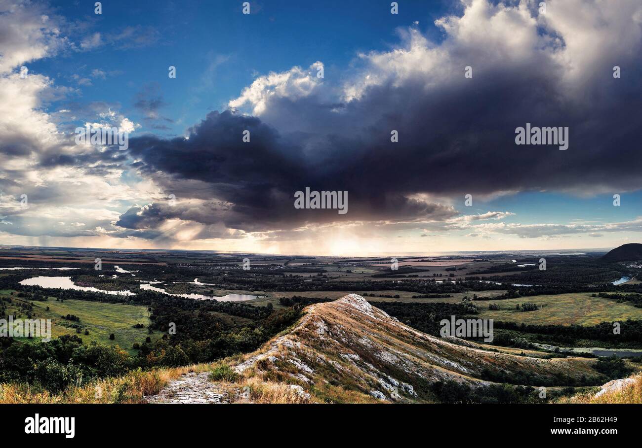 Mountain ridge covered in low clouds with beautiful summer storm rainy ...