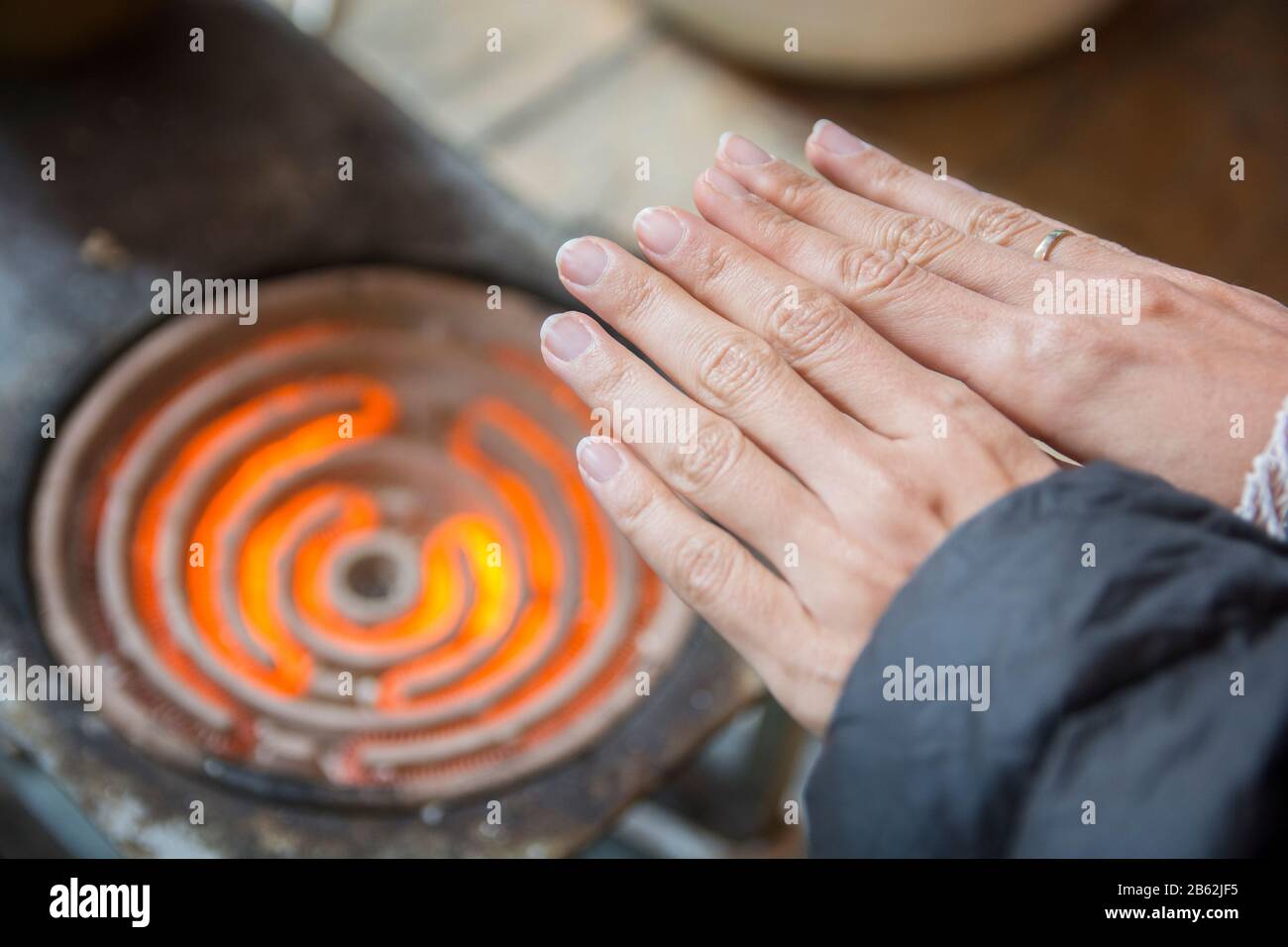 Woman Hands warming above hot stoves Stock Photo - Alamy