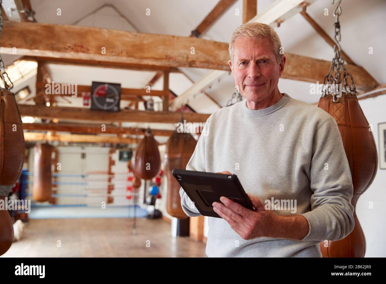 Portrait Of Senior Male Boxing Coach In Gym Tracking Training Using ...