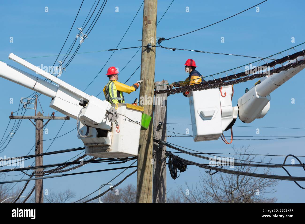 A sequence of images of a wooden electrical utility pole being replaced ...