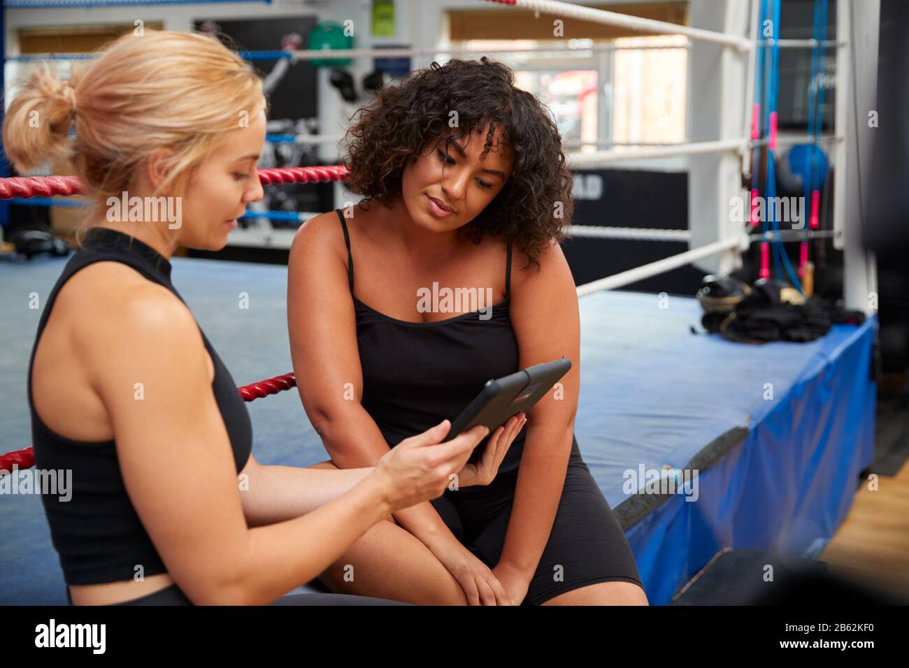 Personal Trainer With Female Boxer In Gym Checking Performance Using ...