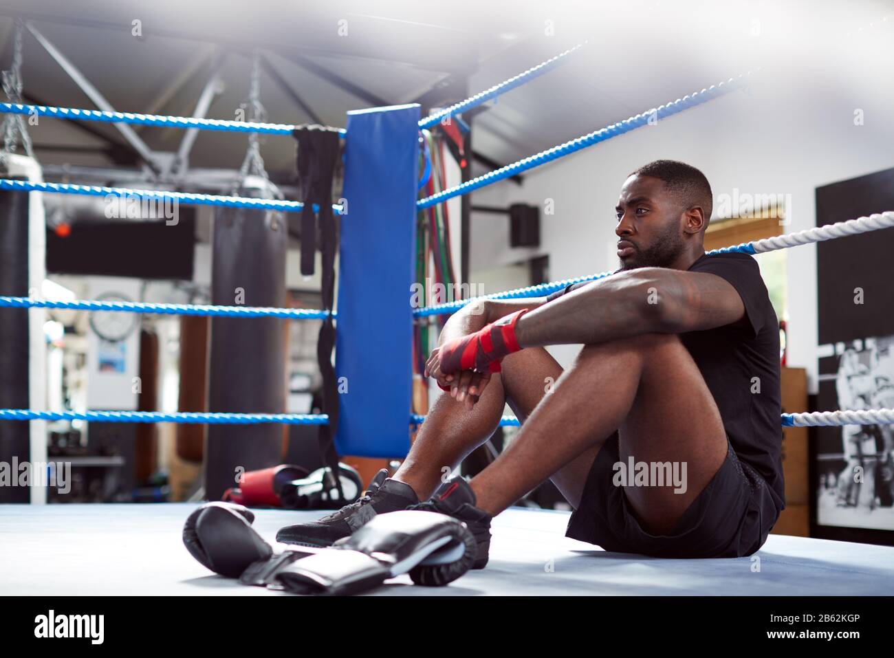 Tired Male Boxer Sitting In Boxing Ring In Gym After Training Session ...