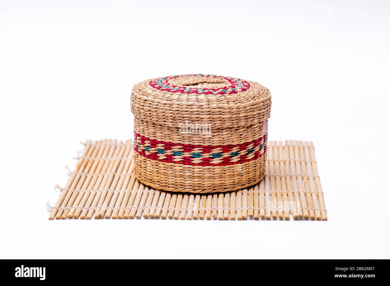 Cylindrical boxes woven from straw on a mat isolated Stock Photo - Alamy
