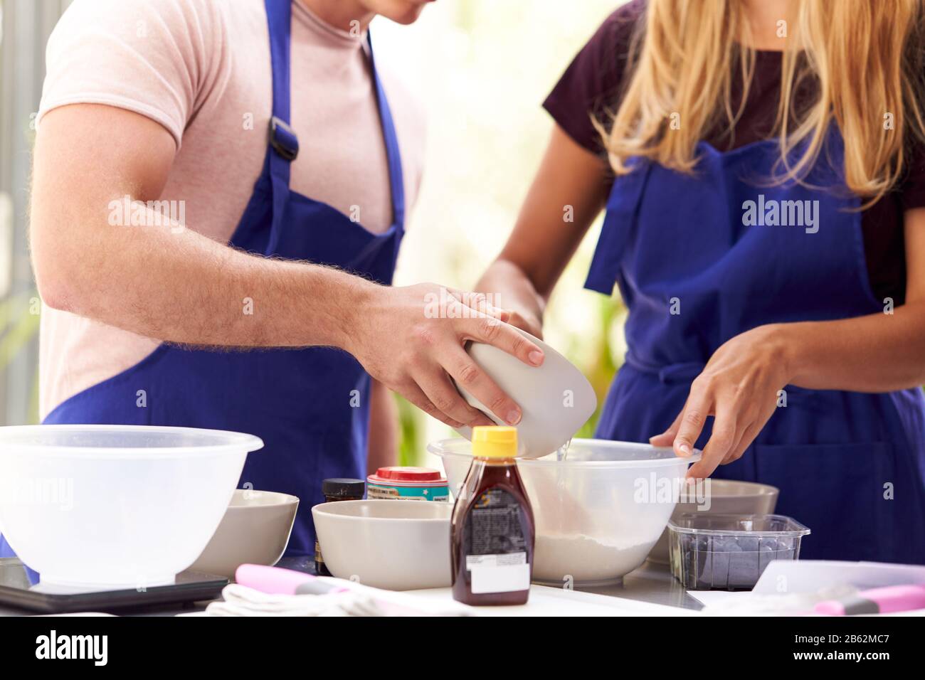 Close Up Of Male And Female Adult Students Measuring Ingredients In ...