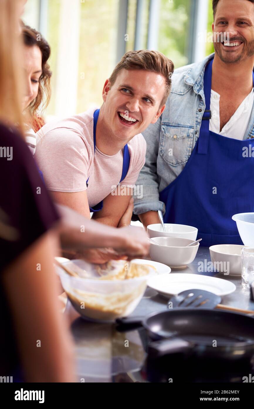 Students Watching Female Teacher Mixing Ingredients In Cookery Class ...