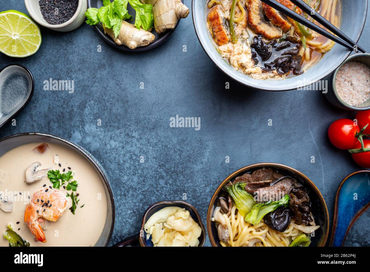 Set of Serving Asian Soups on dark blue background top view. Tom Yum ...
