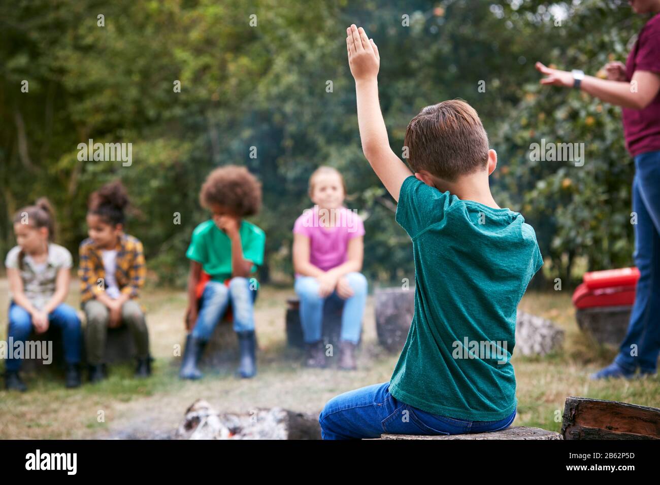Children On Outdoor Activity Camping Trip Sit Around Camp Fire With ...