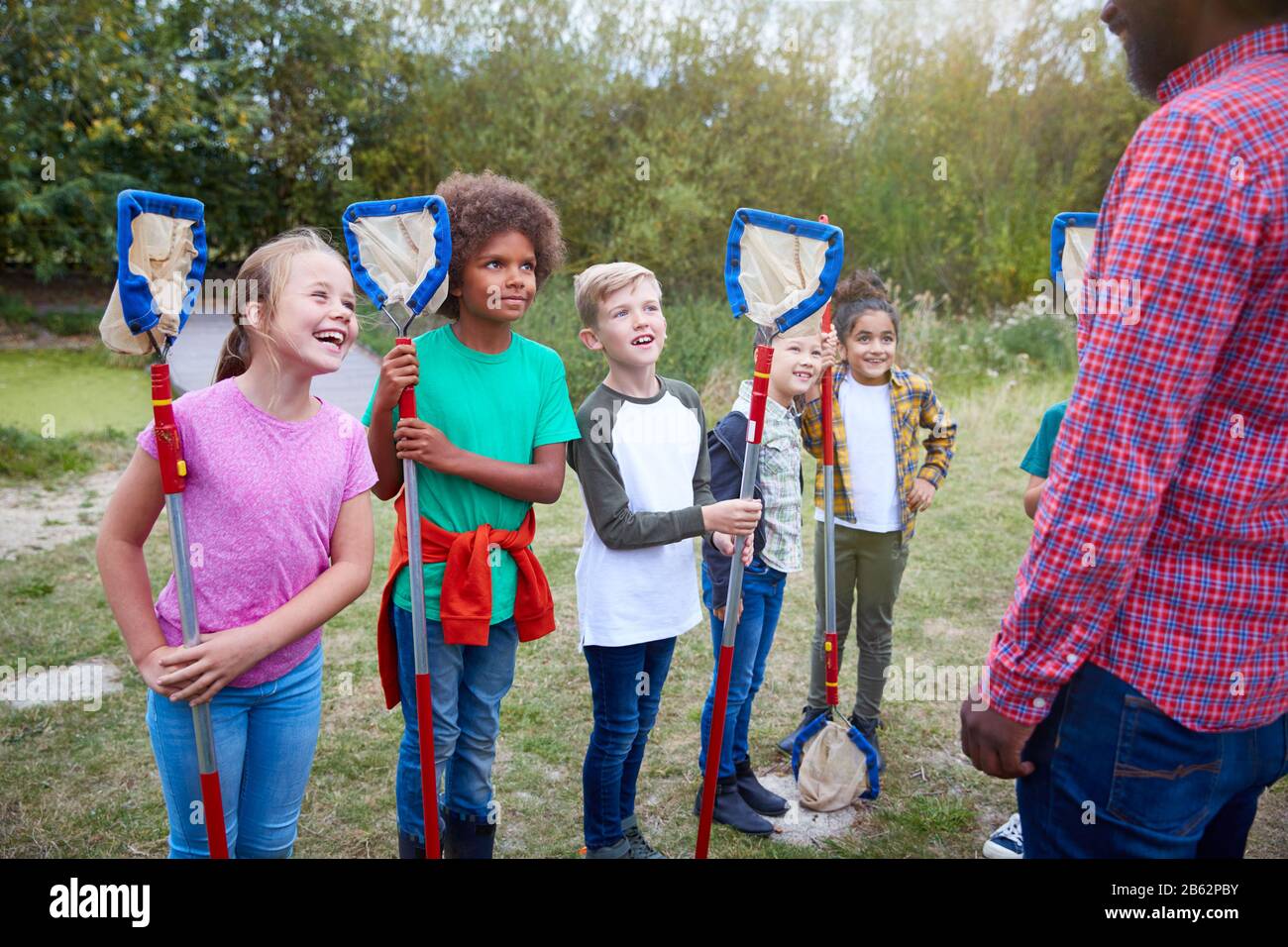 Team Leader And Group Of Children On Outdoor Activity Camp Catching ...