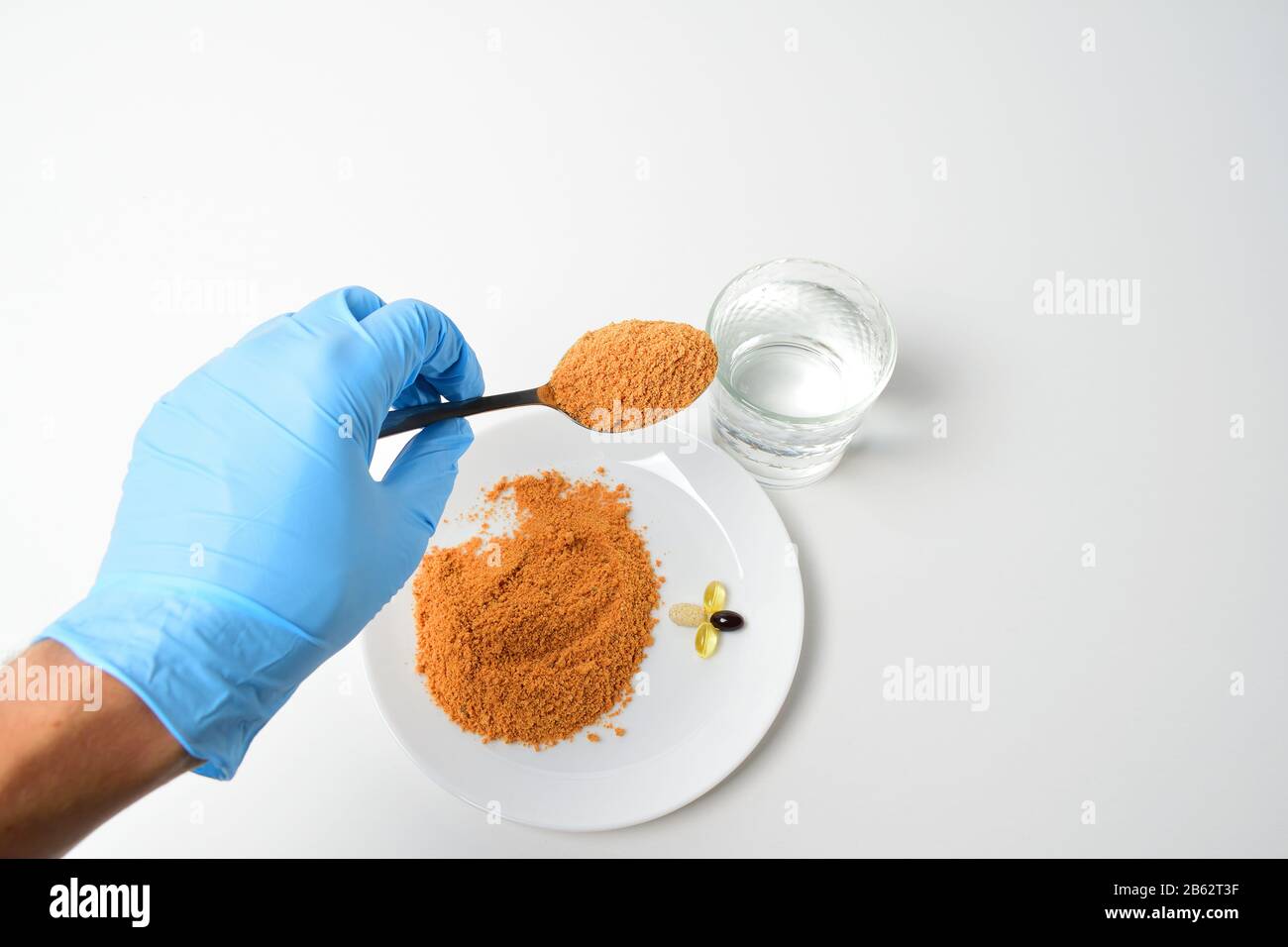 Tomato protein soup powder on a spoon. Hand puts the powder into the ...
