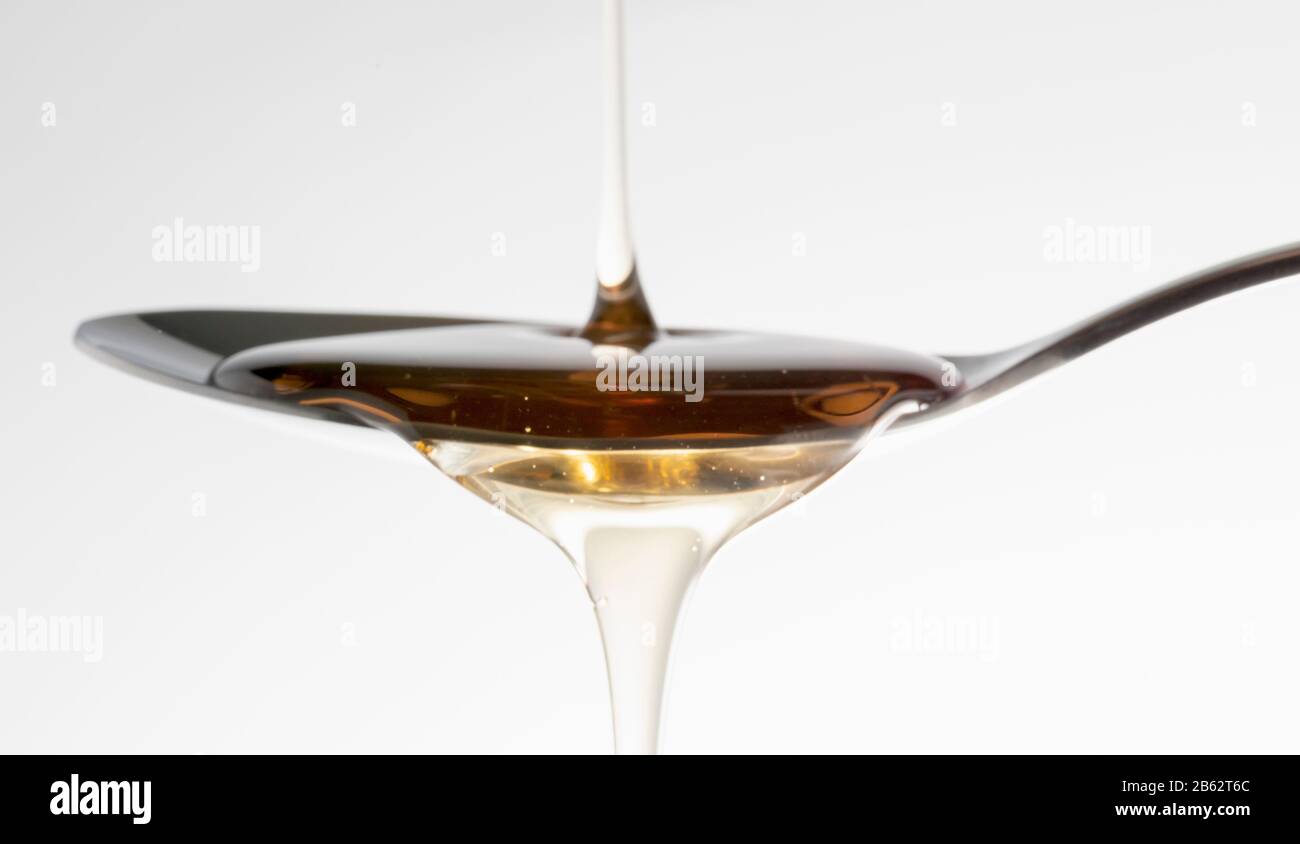 Natural Honey syrup on the spoon Stock Photo - Alamy
