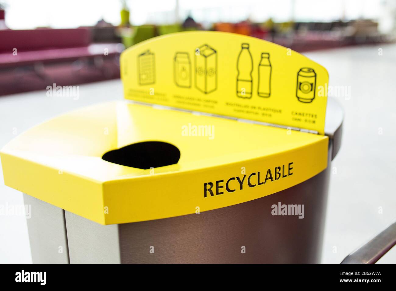 Yellow recycling waste bin indoors Stock Photo - Alamy