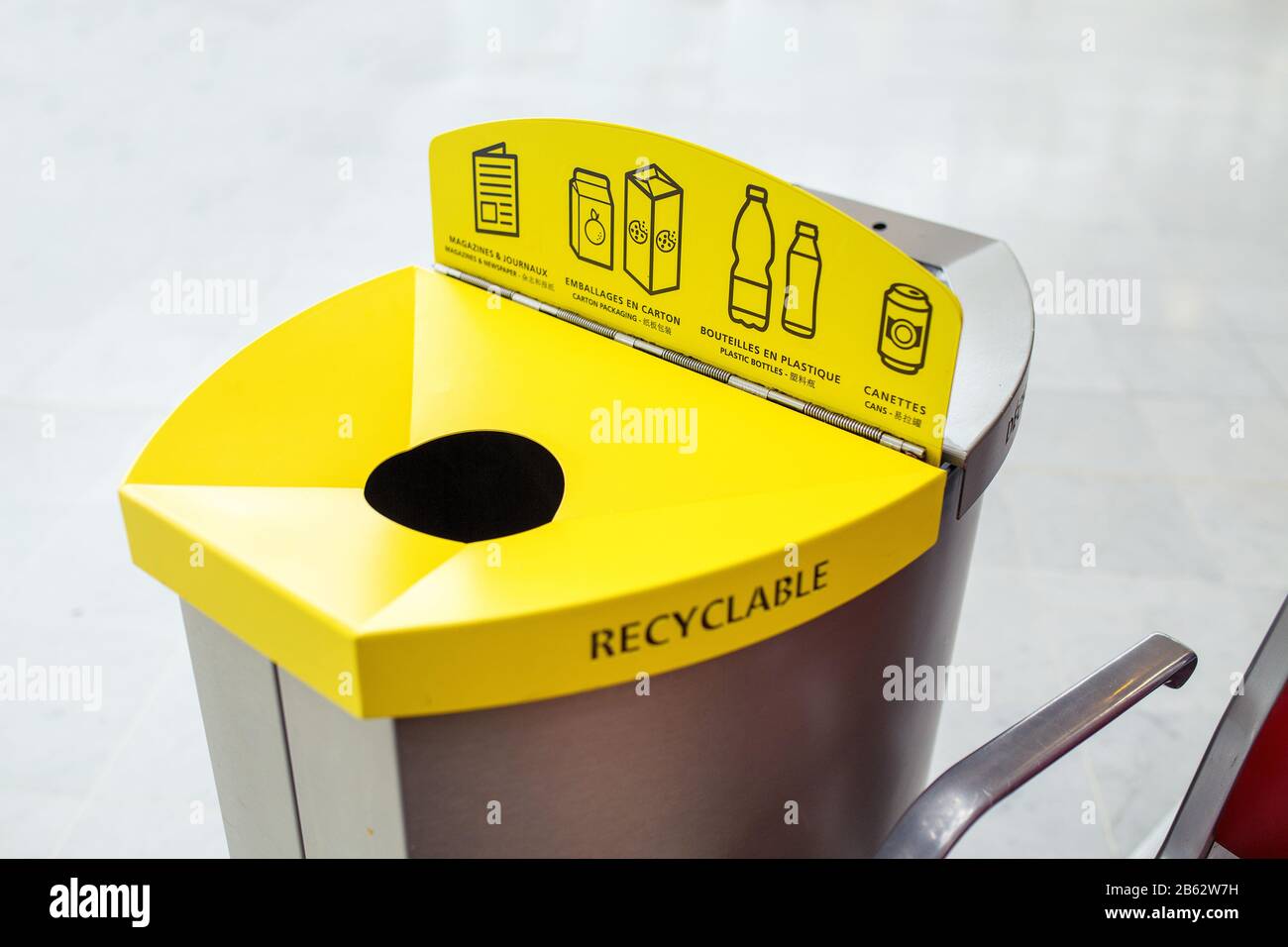 Yellow recycling waste bin indoors Stock Photo - Alamy