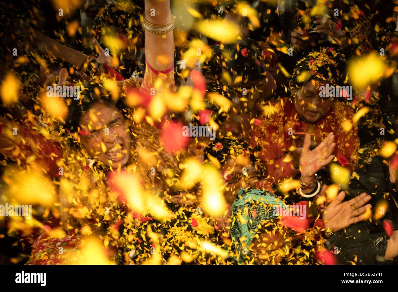 Devotees sing and dance as flower petals are being thrown during the ...