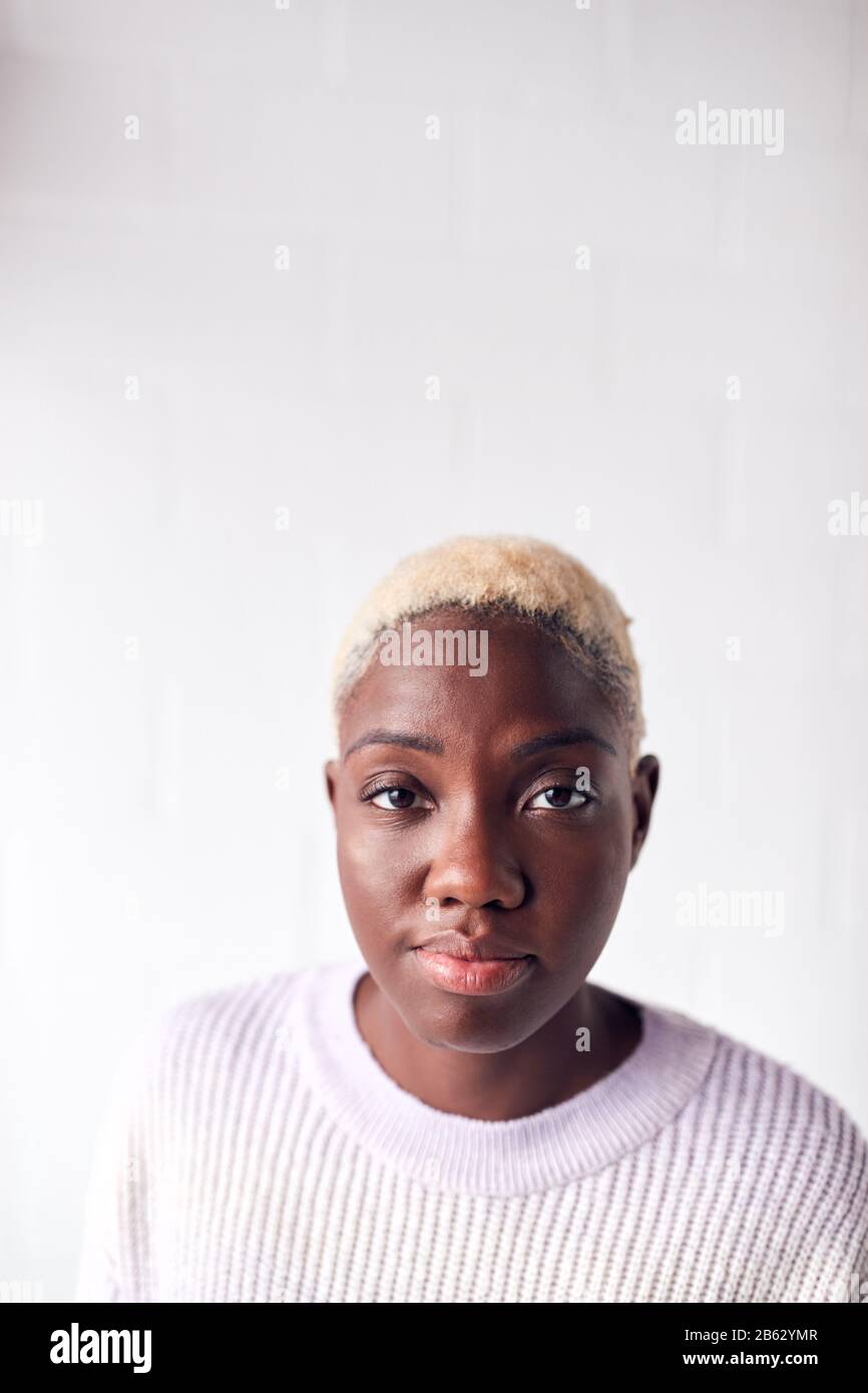 Portrait Of Young Woman Standing Against White Studio Wall Stock Photo ...