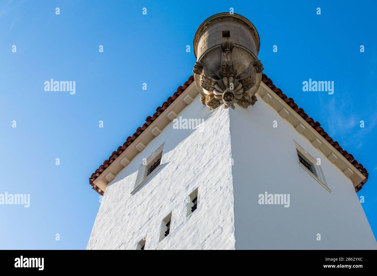 view from below of a majestic white adobe tower with ornate sculpture ...