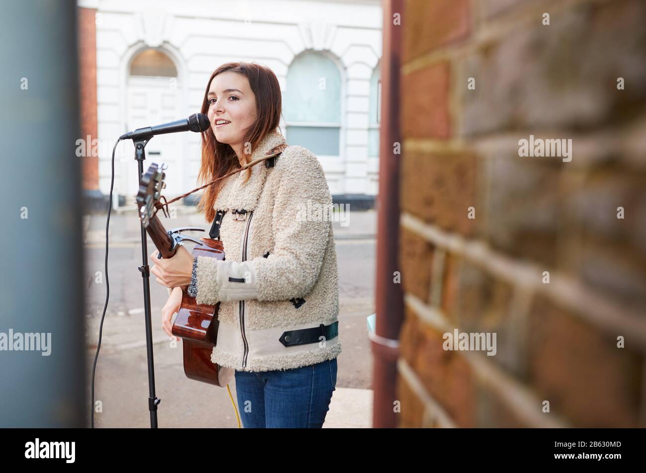 Woman playing guitar singing busking hi-res stock photography and ...
