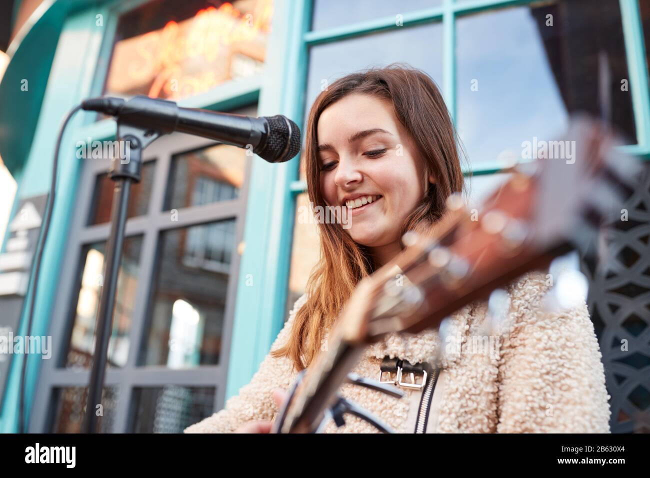 Woman playing guitar singing busking hi-res stock photography and ...