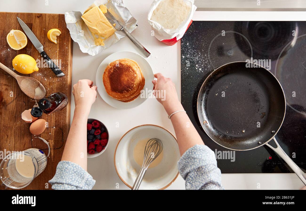 Overhead Shot Of Woman In Kitchen Serving Pancakes Or Crepes For ...