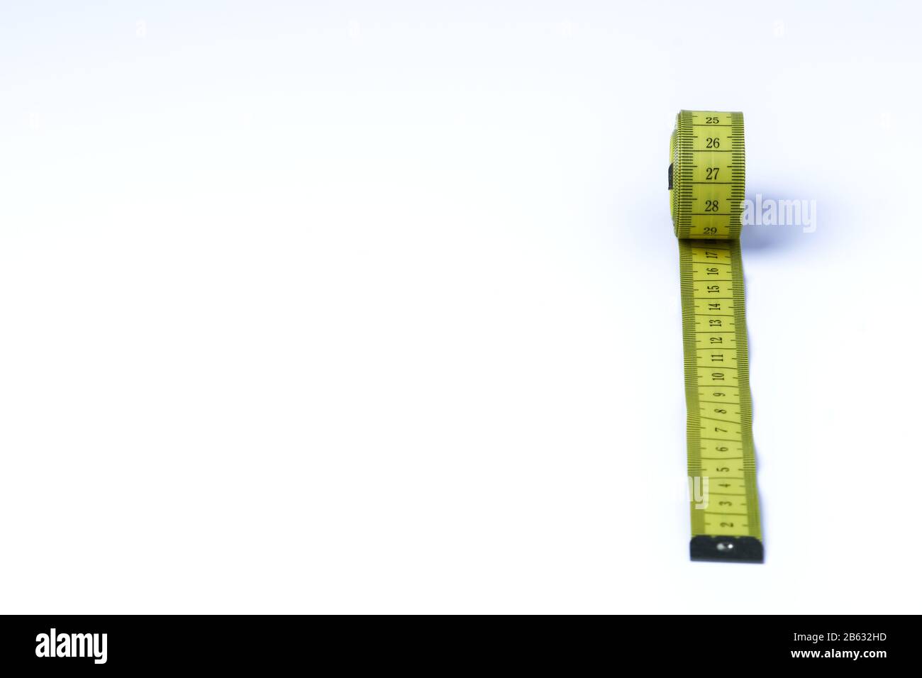 A yellow tape measure in centimeters on a white background Stock Photo ...